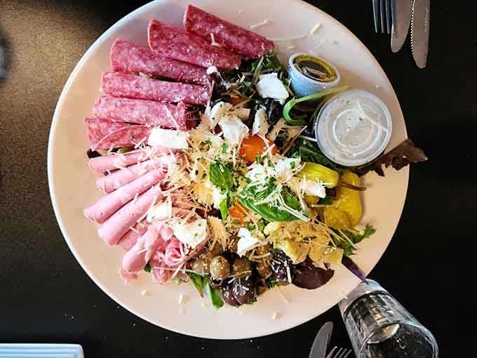 The antipasto salad arranged like edible art—meats, cheeses, and vegetables creating a masterpiece you'll feel guilty destroying with forks.