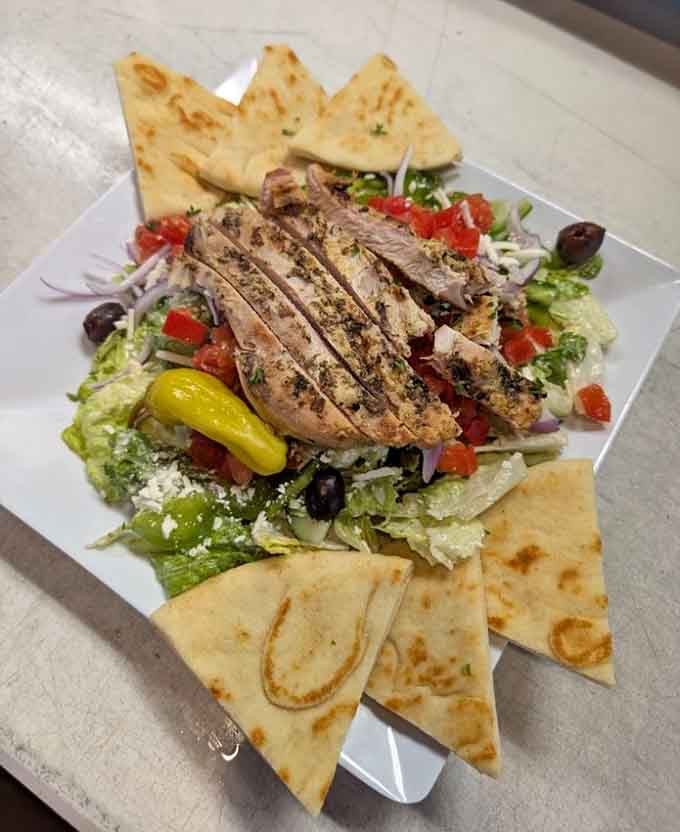 Fresh Greek salad topped with grilled chicken and pita, proving healthy eating doesn't have to be boring.