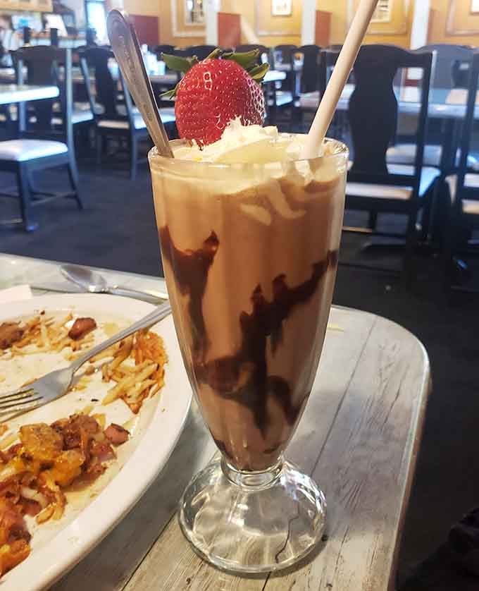 That chocolate milkshake topped with whipped cream and strawberry looks like a 1950s fever dream come true.