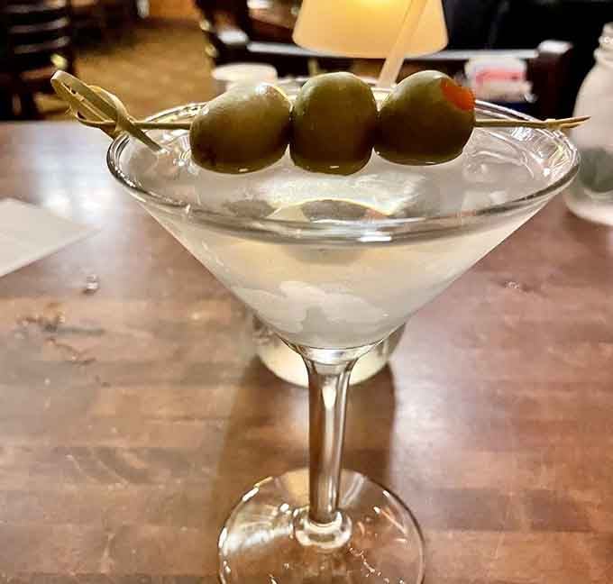 Three olives standing at attention in a martini that means business, because even frontier towns need sophisticated refreshments occasionally.