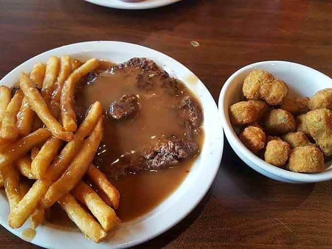 That ribeye steak drowning in gravy with a side of okra is Southern cooking at its most unapologetically delicious.