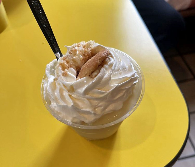 Banana pudding topped with whipped cream and wafer cookies, the perfect sweet ending to your smoky adventure.