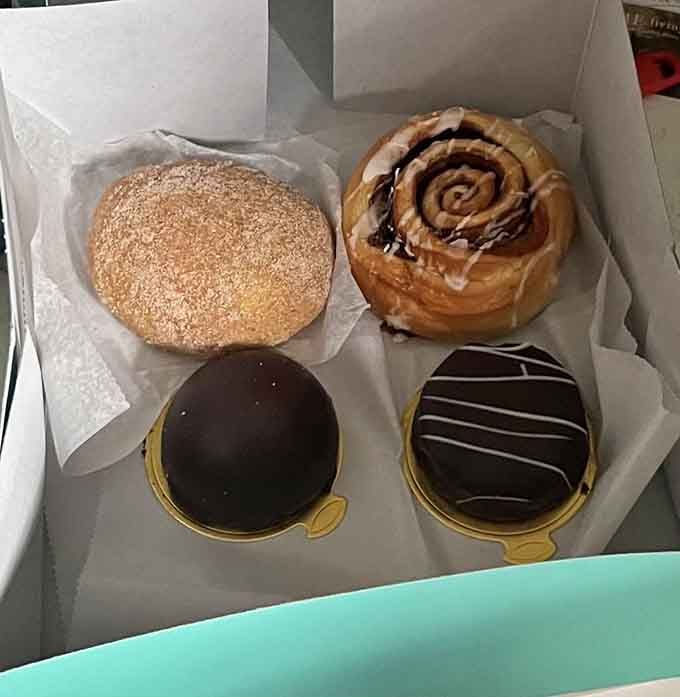 Four pastries in a box representing life's toughest decisions: chocolate glaze, cinnamon swirl, or sesame-topped bliss?