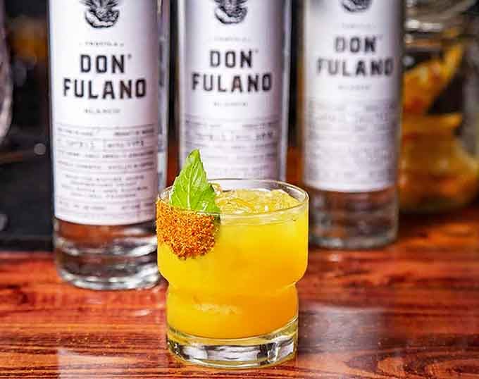 A cocktail so vibrant it looks like sunshine decided to take a vacation in a glass.