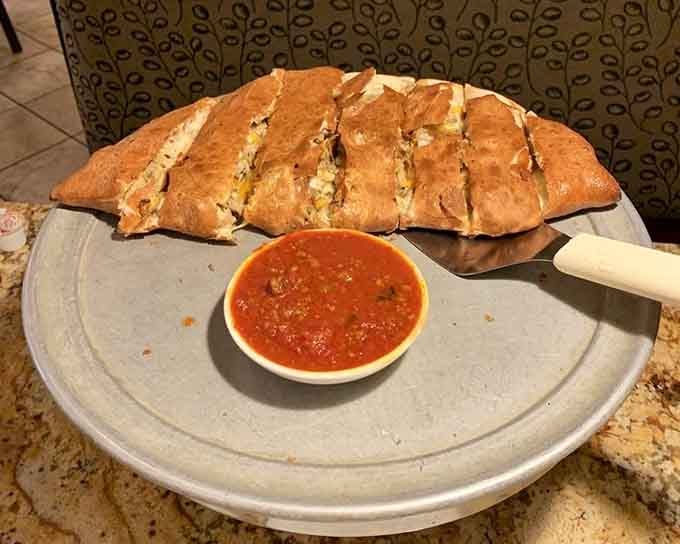 A calzone sliced and ready, revealing its treasure trove of fillings like a delicious Italian present.