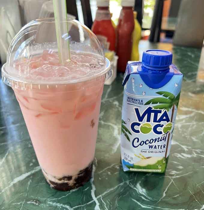 Strawberry milk tea with boba pearls offers a refreshing twist alongside your donut selection at Ruby's.