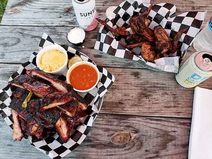 Ribs and wings on weathered picnic wood with checkered paper, because some meals demand an outdoor state of mind.