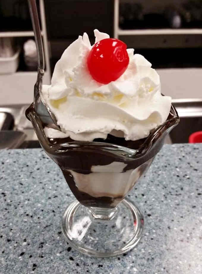 Hot fudge cascading over vanilla ice cream with a cherry on top—some classics never need improvement.