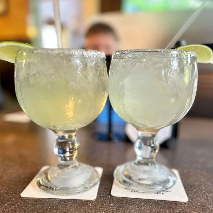Two margaritas with salt-rimmed glasses ready to complement your pizza &ndash; because beach towns understand the assignment perfectly well.