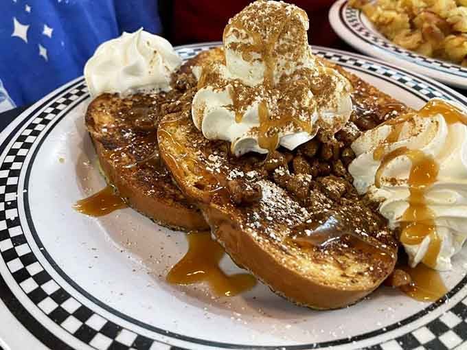 French toast topped with pecans, caramel, and whipped cream, because subtlety is overrated when breakfast dessert calls your name.