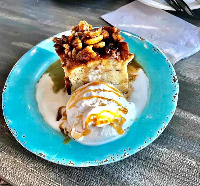 Bread pudding topped with pecans and ice cream, because apparently seafood restaurants also moonlight as dessert wizards.