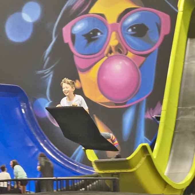 Behind vibrant pop art, kids discover that sliding indoors beats sitting on the couch any day of the week.