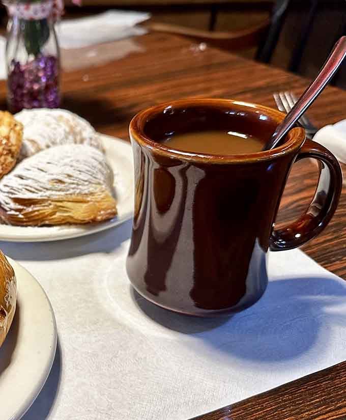 That brown mug holds liquid motivation, the kind that makes early mornings feel like a brilliant life choice.