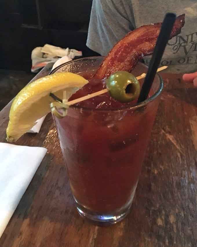 A Bloody Mary garnished with bacon stands tall, because sometimes brunch needs to make a bold statement.