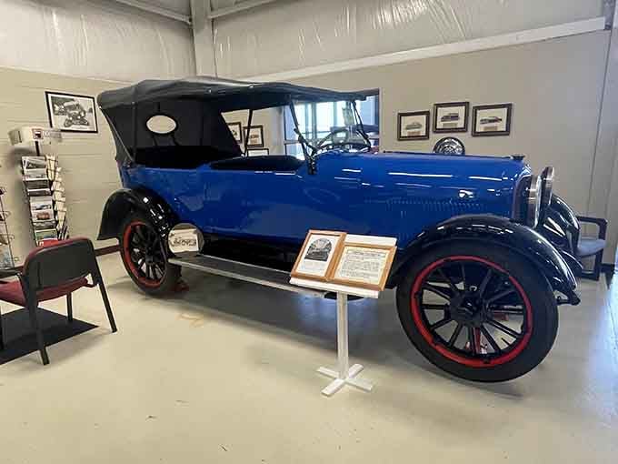 Bright blue paint and red-rimmed wheels make this touring car pop like a vintage postcard come to life.