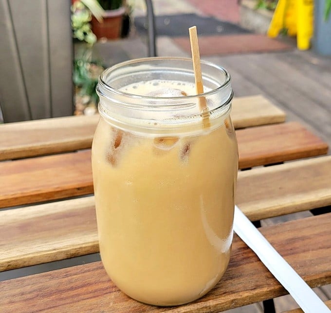 Mason jar iced coffee on weathered wood is the kind of simple pleasure that makes life worth living.