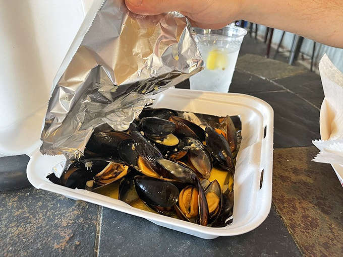 Fresh mussels steaming in their container, ready to transport you straight to seafood heaven with every bite.