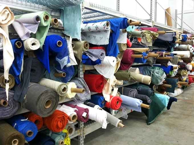 Bolts of fabric stacked like a textile tower of Babel, speaking the universal language of creative potential.