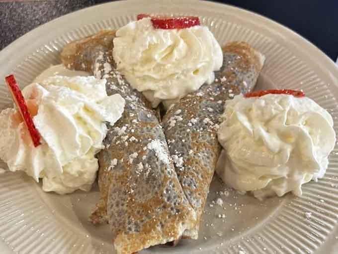 These crepes arrive looking like they just stepped off a Parisian runway, dusted with powdered sugar elegance.