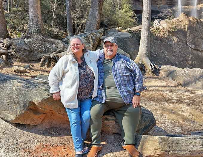 Nothing says "we found paradise" quite like two people grinning on a rock near a 186-foot waterfall.