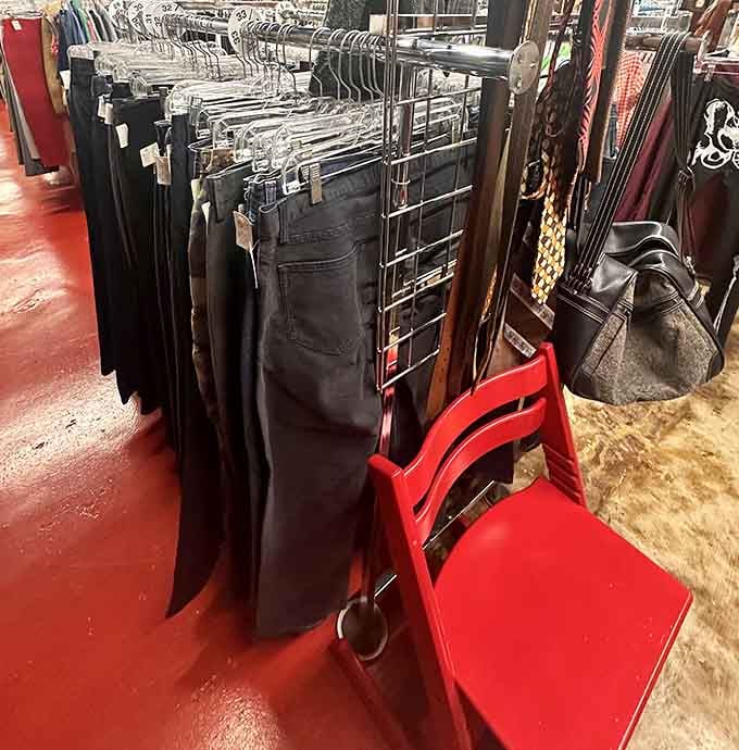 Black jeans and a bright red chair creating a color story nobody asked for but everyone needs.