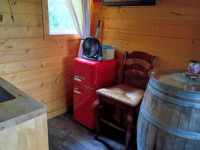 A vintage red fridge in the woods is giving serious retro cabin vibes, minus the questionable electrical wiring.