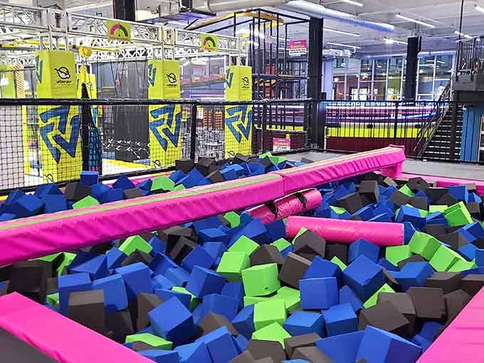 Pink balance beams over foam pits: where grace meets gravity and gravity usually wins, but nobody really minds the outcome.