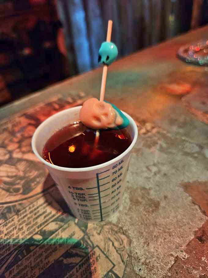 Sometimes your drink arrives in a beaker with skull stirrers, because normal glassware is clearly overrated here.