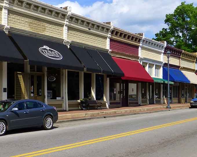 Colorful awnings pop against historic facades like ribbons on a perfectly wrapped gift from another era entirely.