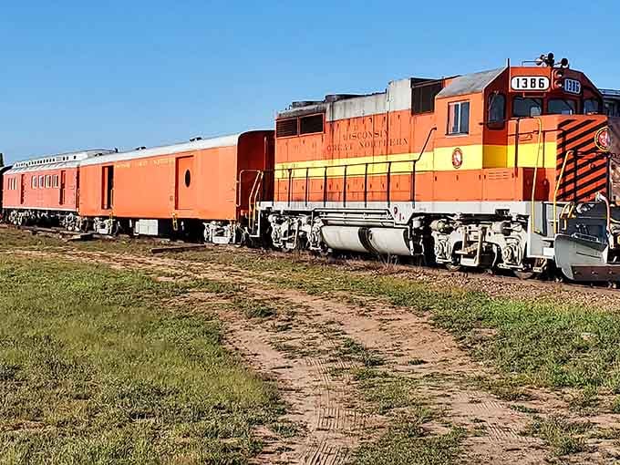 That bright orange and yellow locomotive isn't compensating for anything, it's celebrating pure vintage railroad glory.