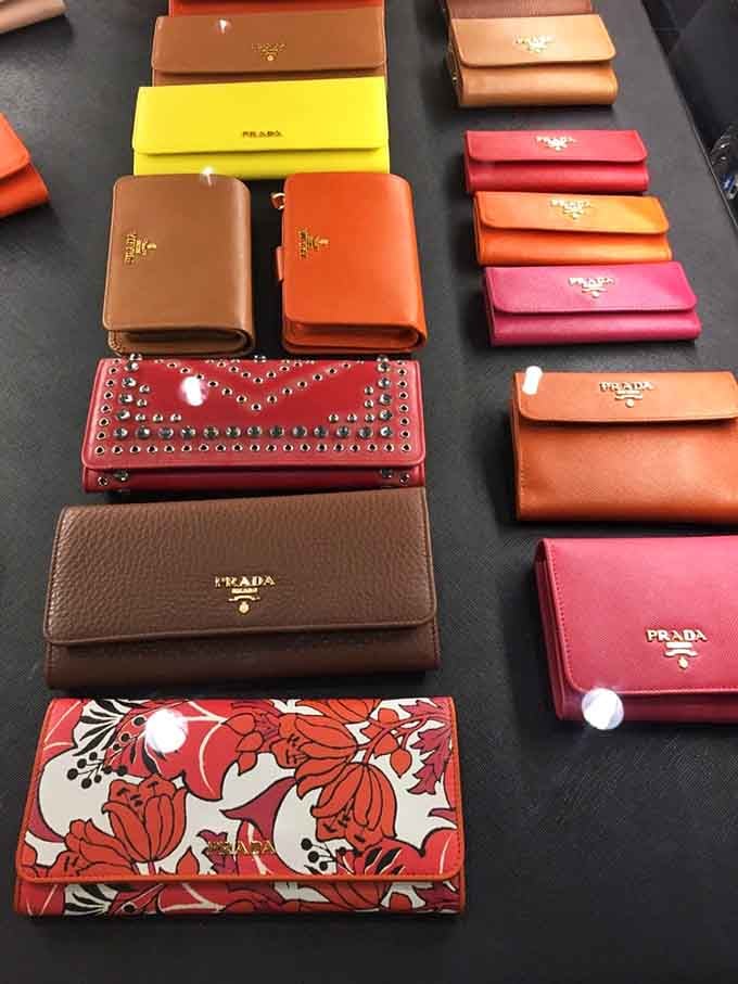 Prada wallets arranged like precious jewels, proving that even practical items deserve their moment to shine in the spotlight.