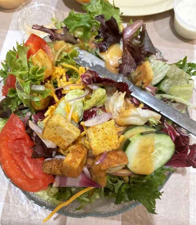 Even the side salad gets the royal treatment here, loaded with fresh vegetables and enough toppings to qualify as dinner.