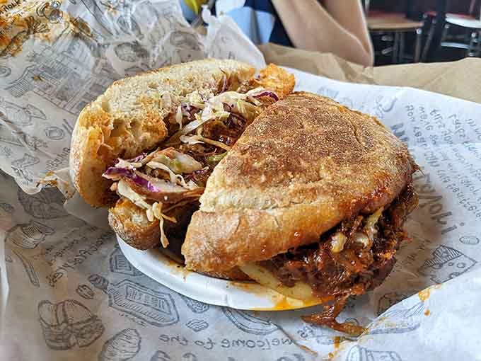 Beef brisket piled high between fresh bread, creating a masterpiece that requires strategic planning to eat properly.