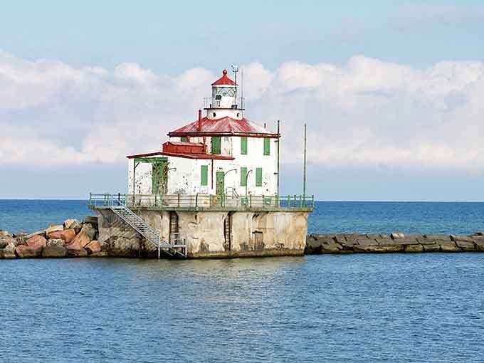 Time-worn and weathered, this green-shuttered lighthouse wears its patina like badges of honor from countless seasons.