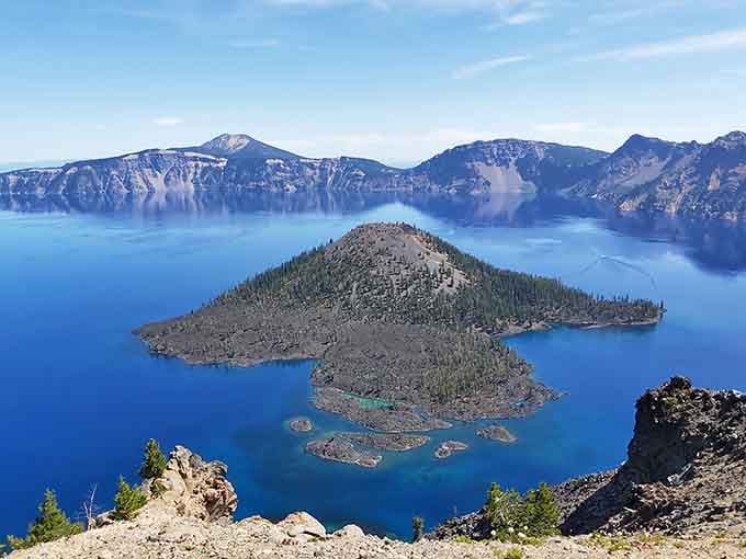 Wizard Island floats in impossibly blue water inside a volcanic crater that defies every expectation you had.