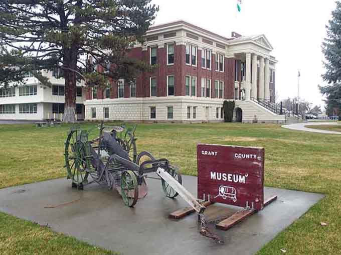 The courthouse stands proud with classical columns while antique farm equipment honors the hardworking agricultural heritage here.