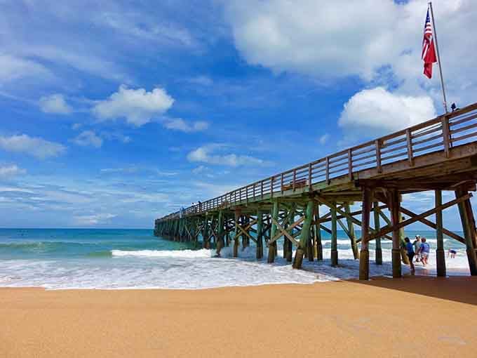 The wooden pier stretches toward the horizon, beckoning beachgoers to walk above the rolling Atlantic waves.