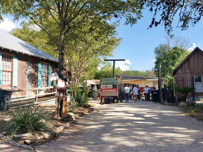 Rustic buildings and shaded pathways create an authentic Old West atmosphere where history lives on in every weathered board.