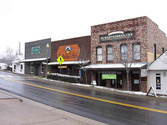 Historic brick buildings line the quiet street where small-town charm meets genuine Southern hospitality and character.