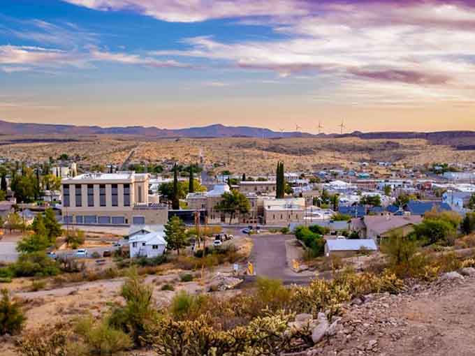 Dramatic skies paint the hillside town in purple and gold, nature's daily masterpiece on display.