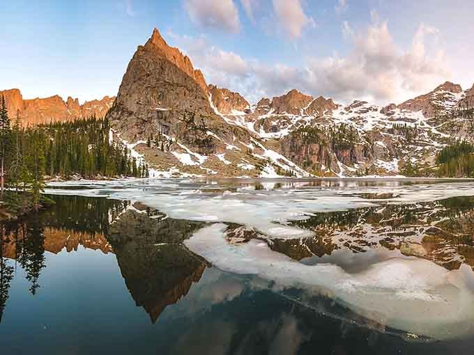Lone Eagle Peak's reflection doubles its majesty, creating symmetry that seems almost too perfect to be natural.
