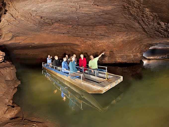 Underground adventurers glide through nature's hidden waterway on a journey into Kentucky's mysterious depths below.