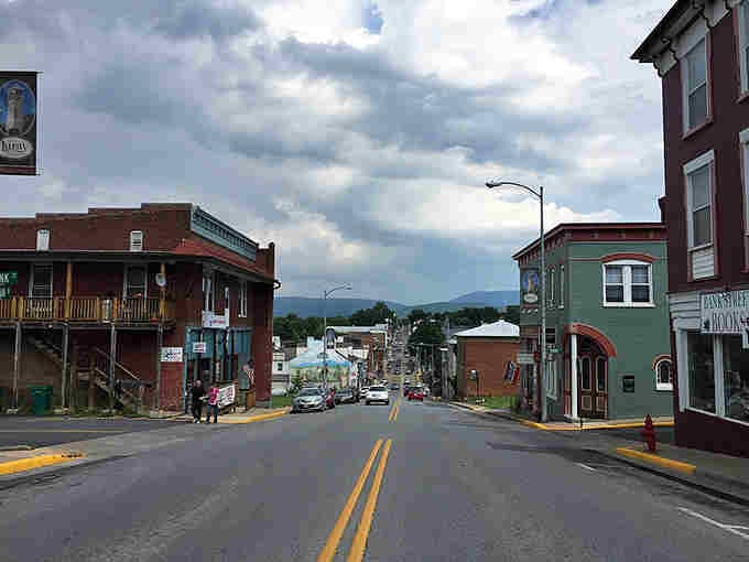 Mountains roll into the distance beyond colorful buildings, reminding you why people write songs about these hills.