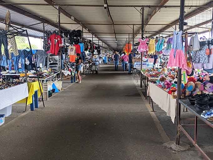 Covered walkways stretch between colorful vendor displays where families browse together like it's their favorite Saturday morning tradition come alive.