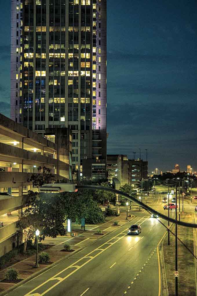 Evening descends on glass and steel, transforming ordinary streets into ribbons of light that guide night owls home safely.