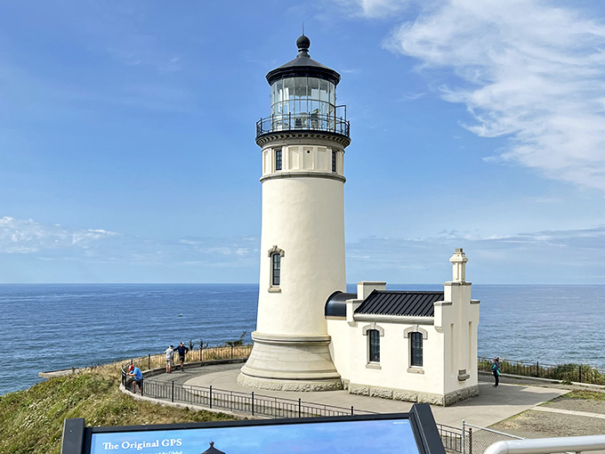 This pristine lighthouse stands guard over endless Pacific waters, its classic white tower gleaming against the brilliant blue horizon.