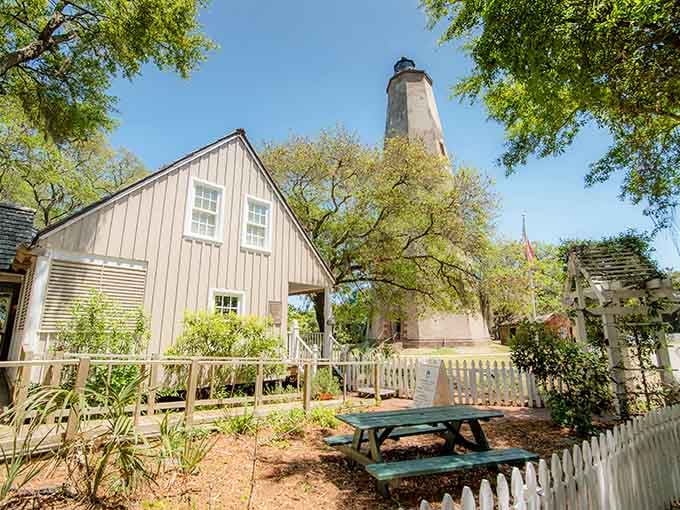 The historic lighthouse tower rises above coastal buildings like a faithful sentinel watching over generations of island visitors and residents.