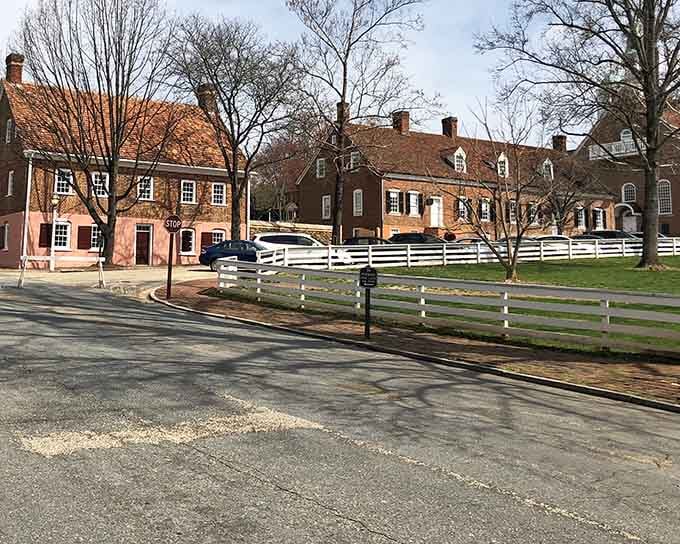 White picket fences and brick colonial buildings lined up like a perfectly preserved 18th-century European settlement street.