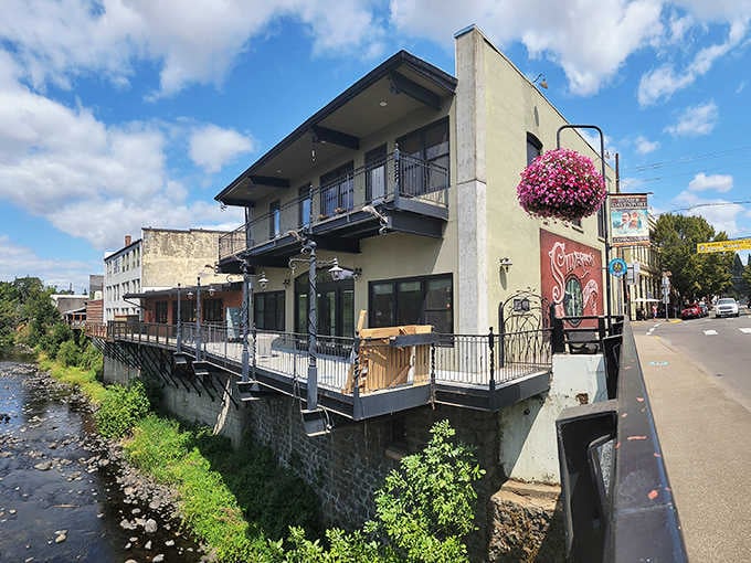 Flowers cascade from hanging baskets above the creek-side restaurant, adding color to this charming riverside setting.
