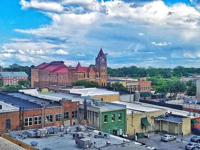 That stunning clock tower rises like a Victorian-era beacon above tree-shaded streets where history lives in every brick.